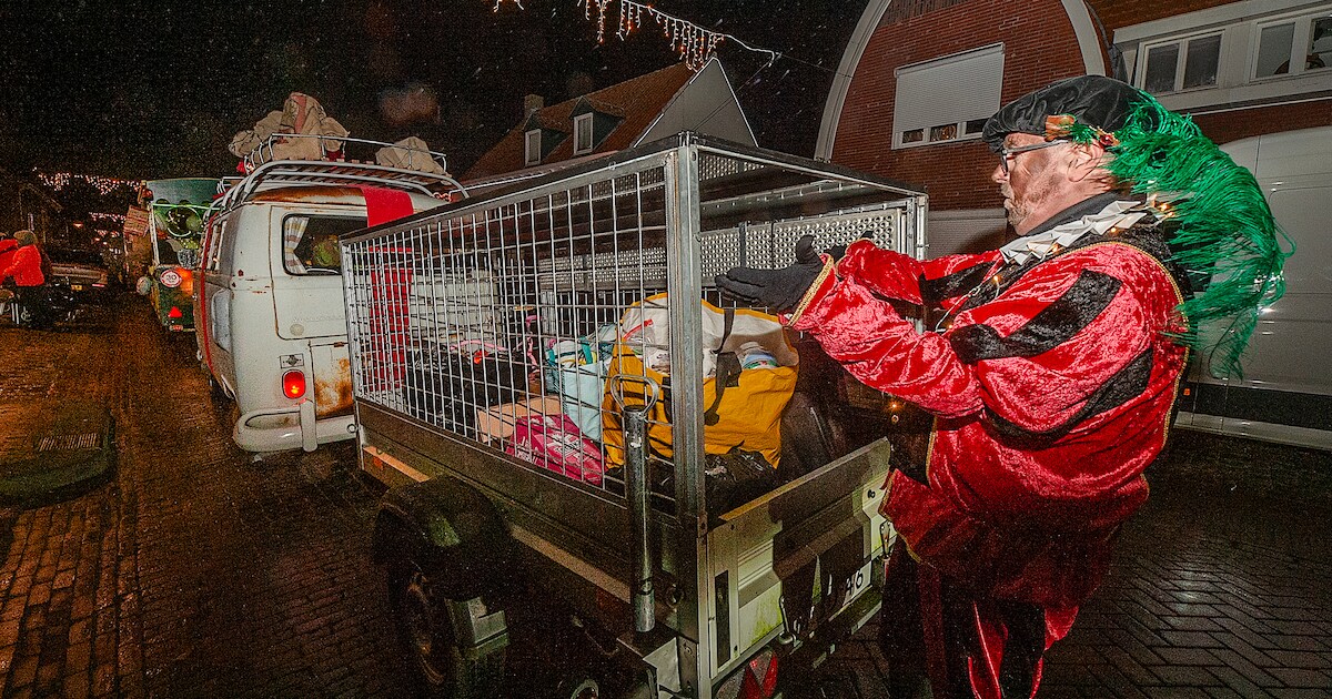 Kayleigh (7) geeft haar poppenbuggy aan Piet tijdens de Sintintocht ...