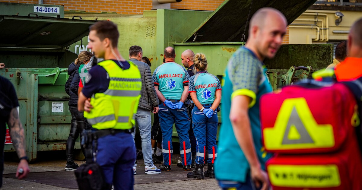 Man klimt in container met afvalpers bij station Eindhoven ...