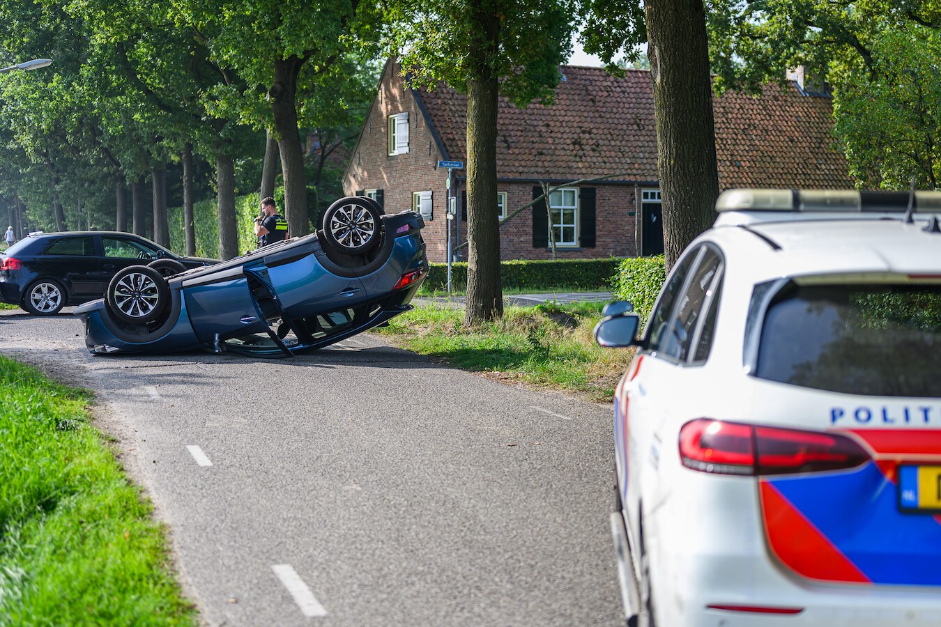 Auto over de kop bij botsing in Sprundel: bestuurder door buurtbewoners ...