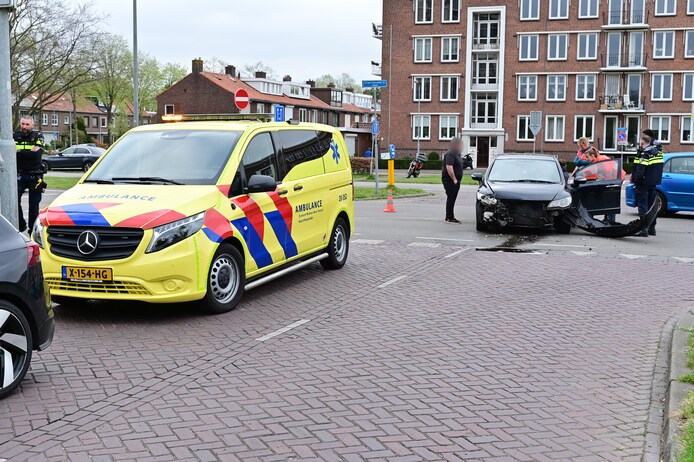 Taxi en auto botsen op elkaar op kruising in Breda, inzittende nagekeken door ambulancepersoneel ...